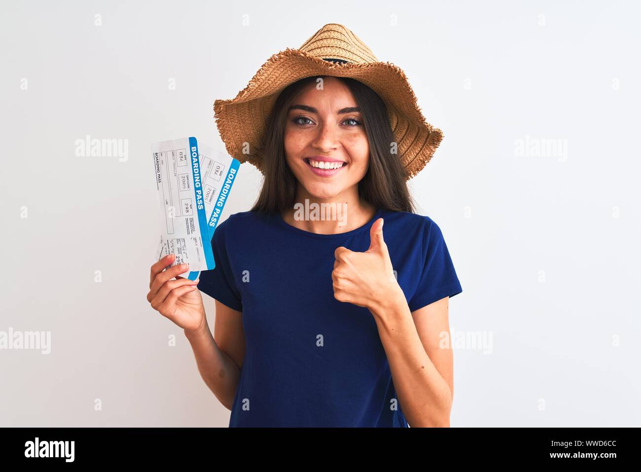 Young beautiful tourist woman holding boarding pass ticket over ...