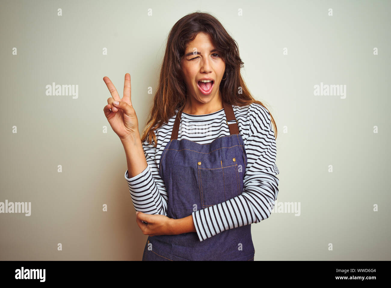 Young beautiful chef woman wearing apron cooking over white isolated ...