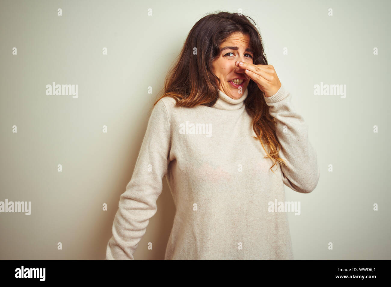 Young beautiful woman wearing winter sweater standing over white ...