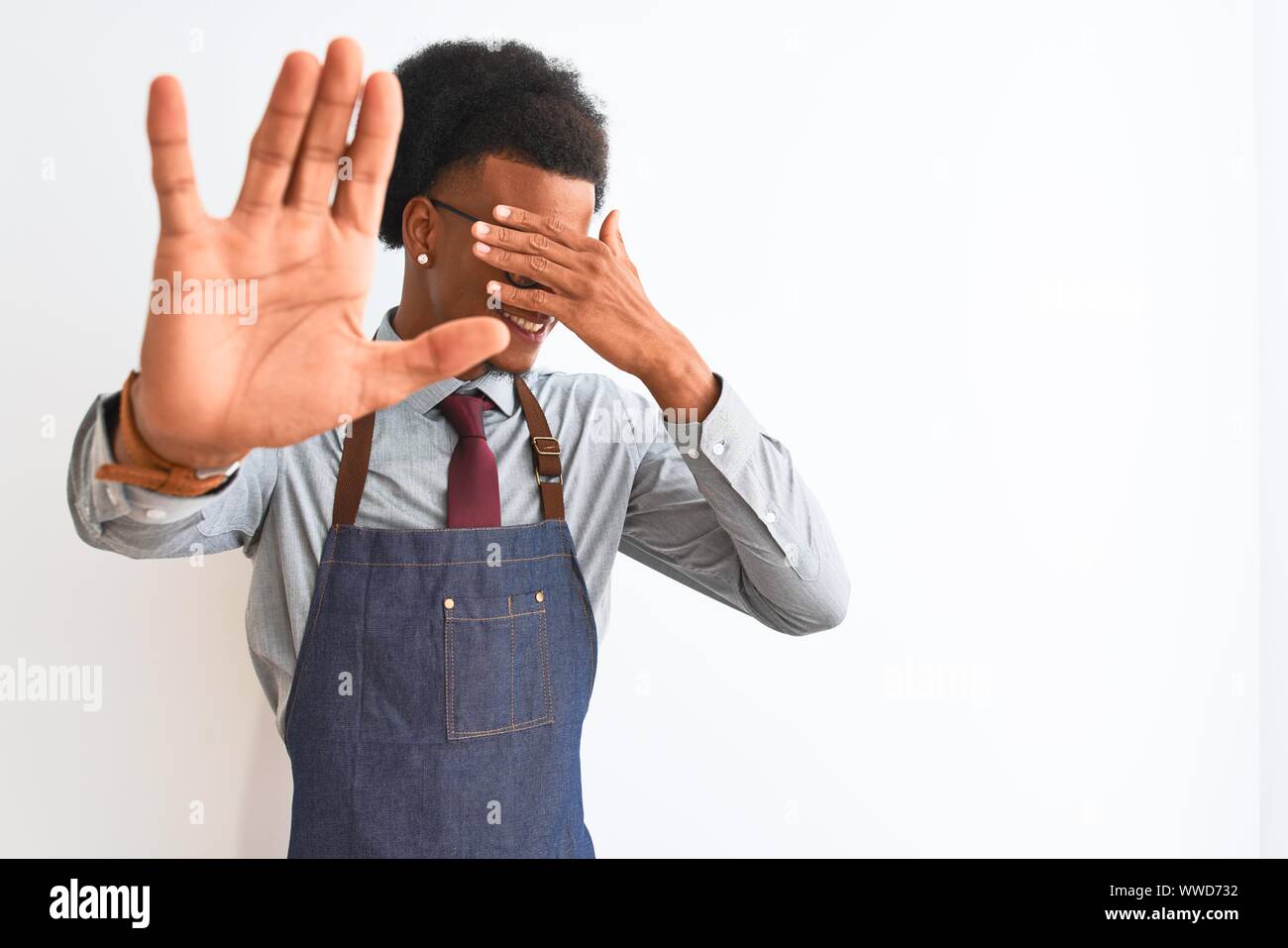Young african american shopkeeper man wearing apron glasses over ...