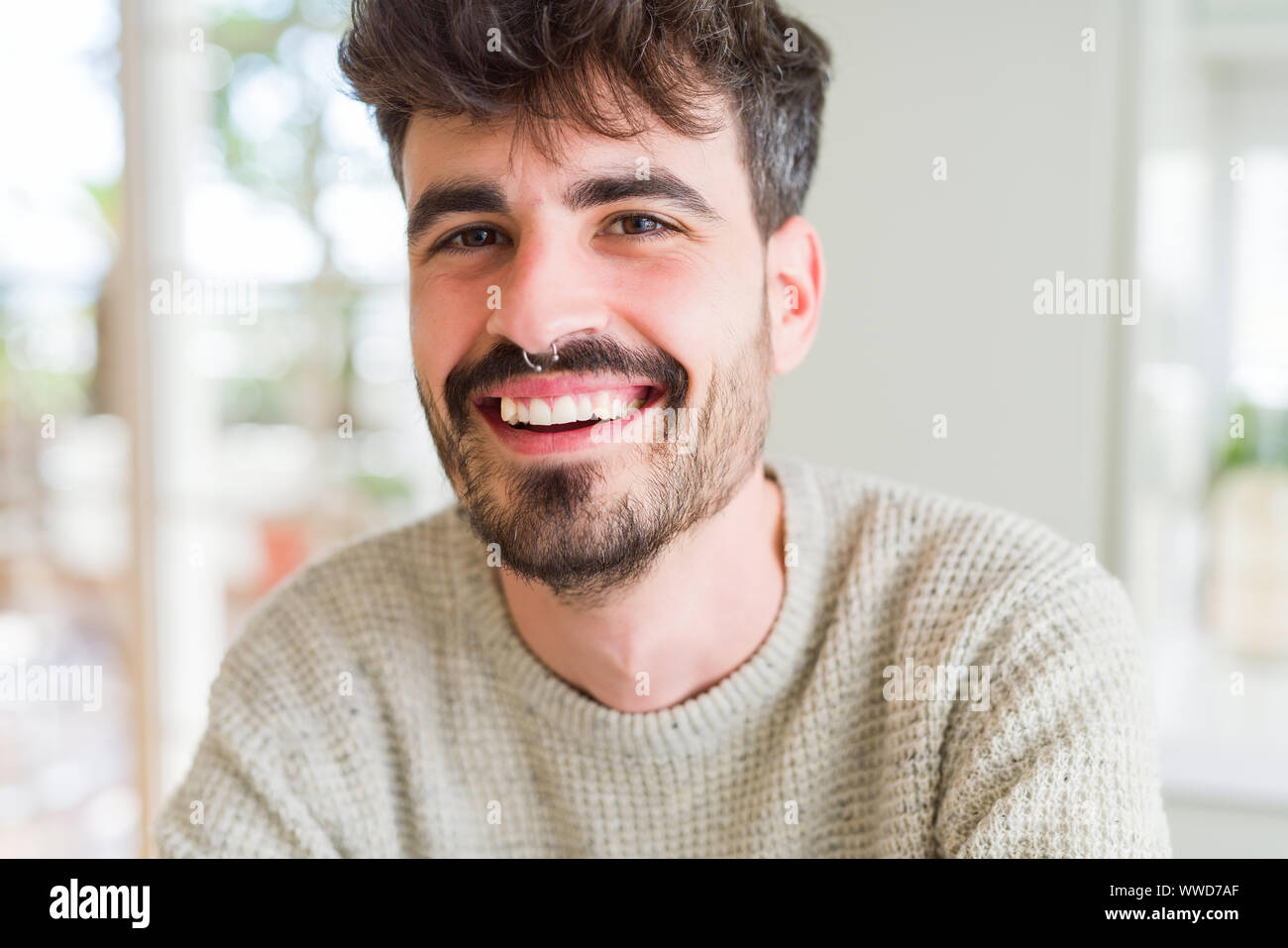 Handsome young man smiling cheerful at the camera with a big smile on ...