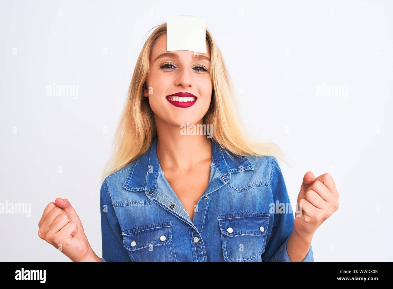 Beautiful woman with reminder sticker paper on forehead over isolated ...