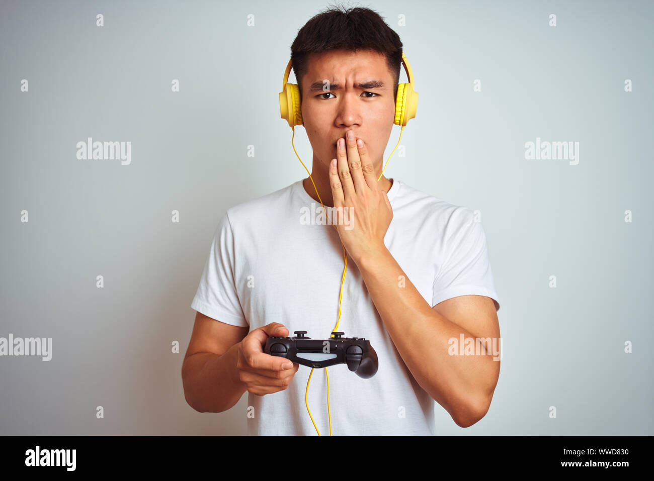 Young asian chinese gamer man playing video game standing over isolated ...