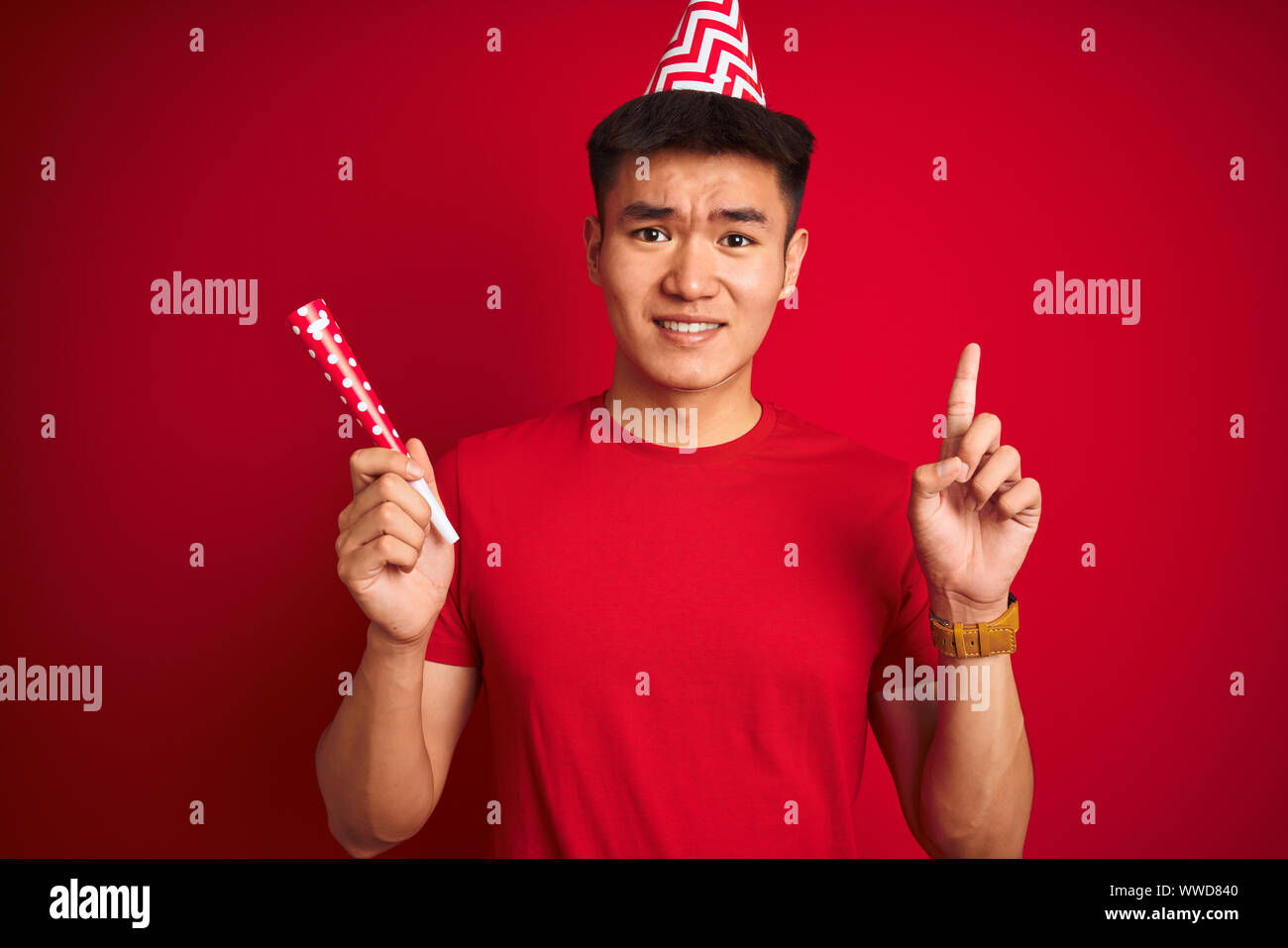Asian chinese man on birthday celebration wearing funny hat over ...