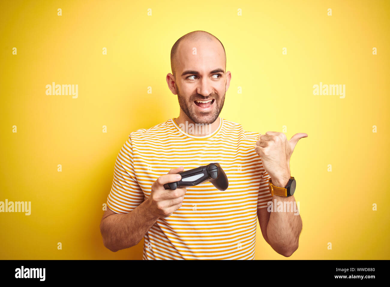 Young man playing video games using joystick gamepad over isolated ...