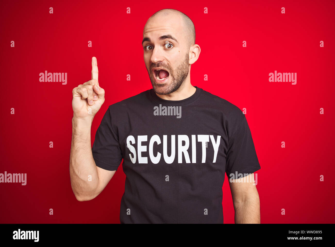 Young safeguard man wearing security uniform over red isolated ...