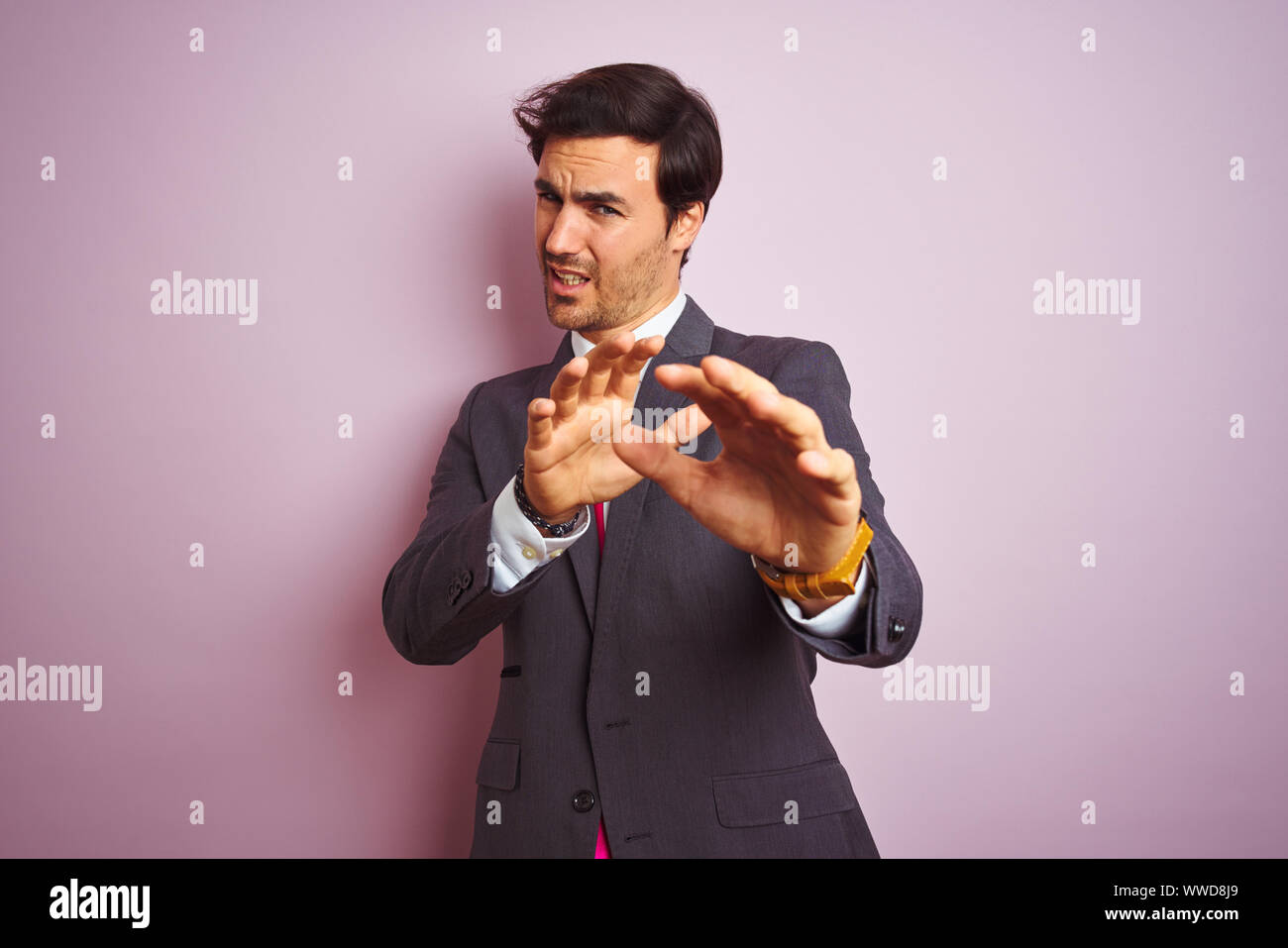 Young handsome businessman wearing suit and tie standing over isolated ...