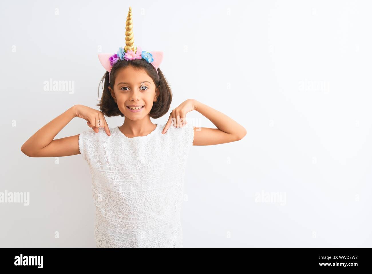 Beautiful child girl wearing unicorn diadem standing over isolated ...