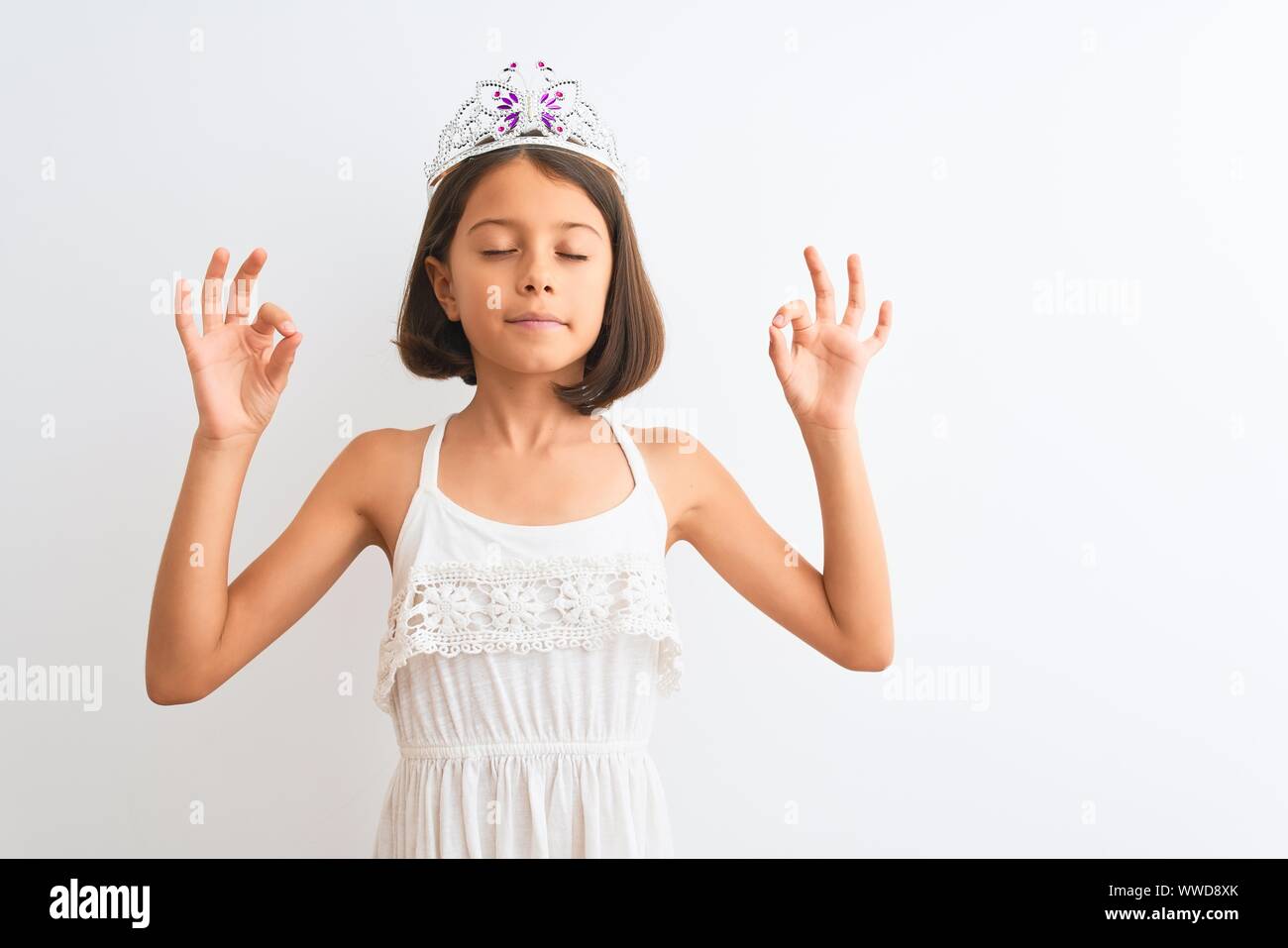 Beautiful child girl wearing princess crown standing over isolated ...
