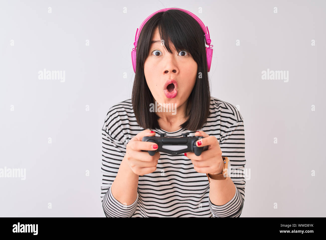 Chinese gamer woman playing video game using headphones over isolated ...