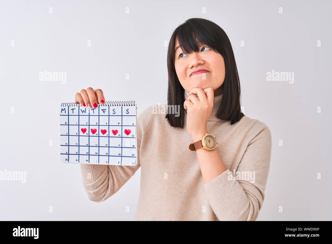 Young beautiful Chinese woman holding menstruation calendar over ...