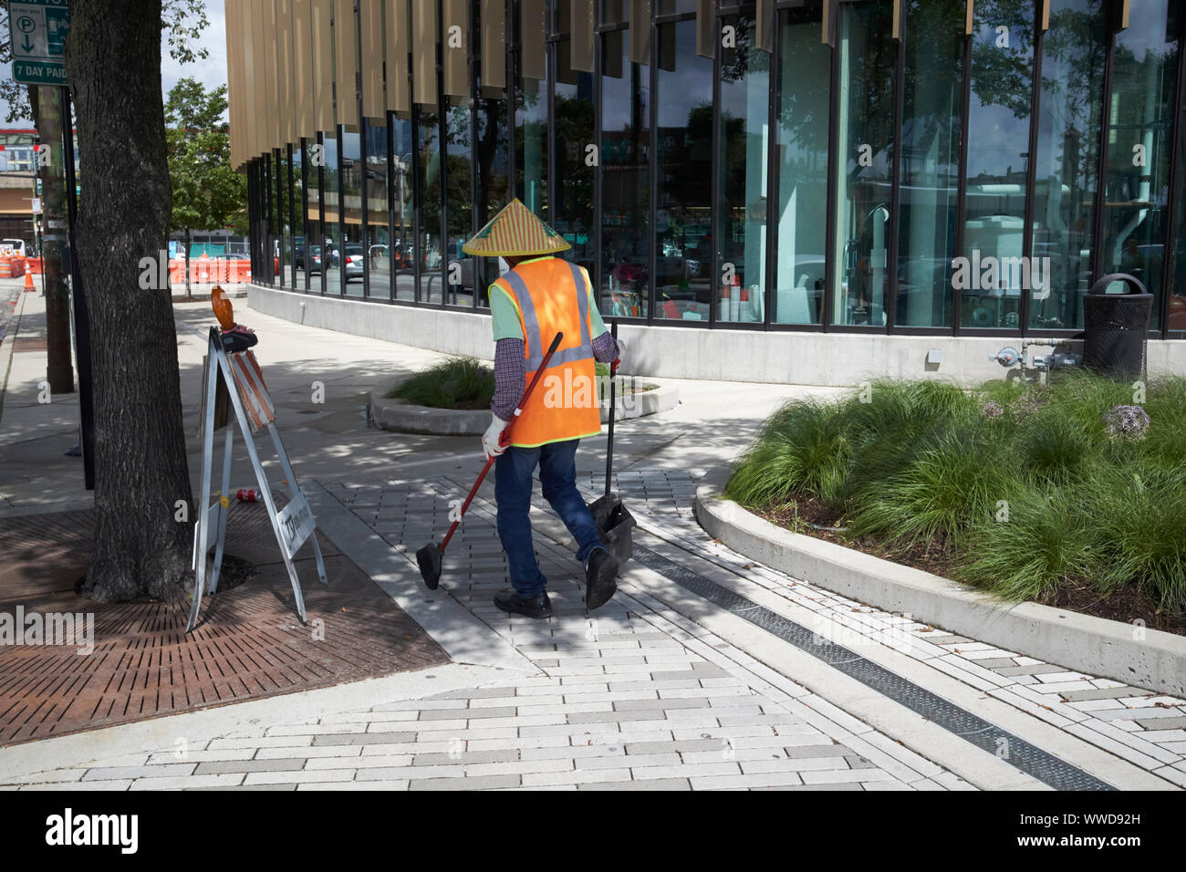 old man street cleaner wearing high vis vest and chinese conical hat ...