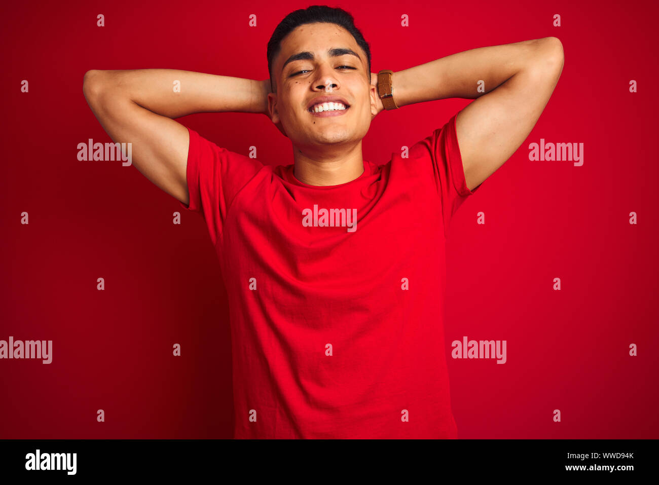 Young brazilian man wearing t-shirt standing over isolated red ...