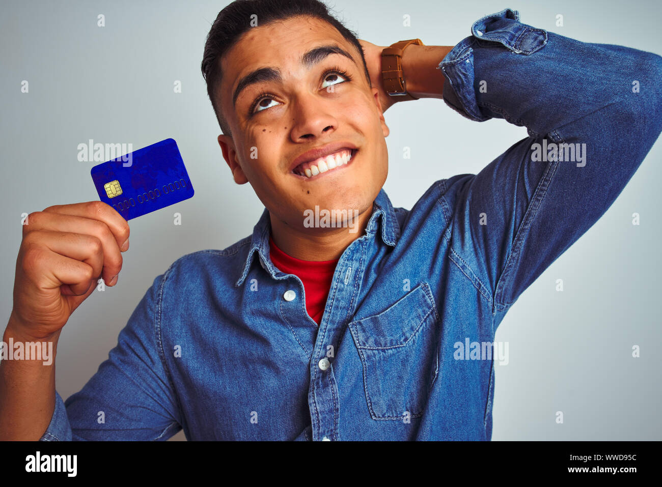 Young brazilian customer man holding credit card standing over isolated ...