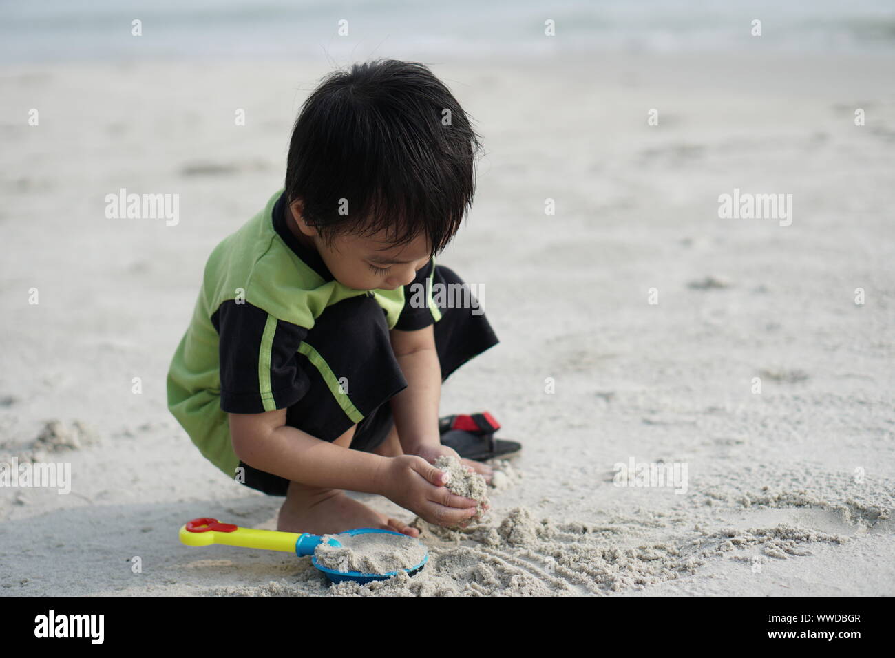 boy playing with sand on the beach Stock Photo - Alamy