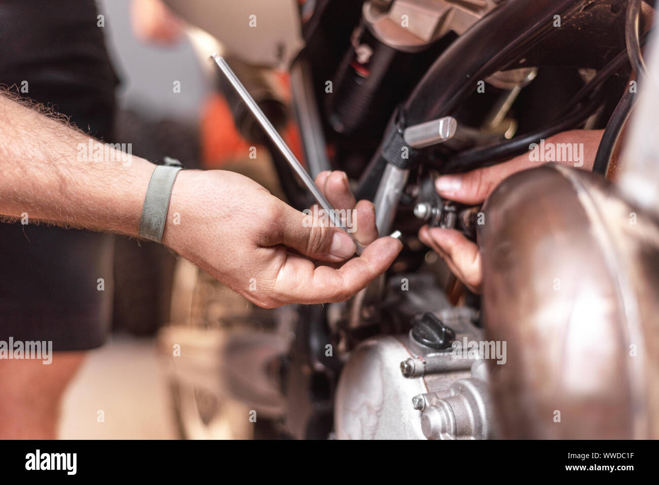 Mechanic Repairing A Motorbike Engine In A Workshop Stock Photo - Alamy