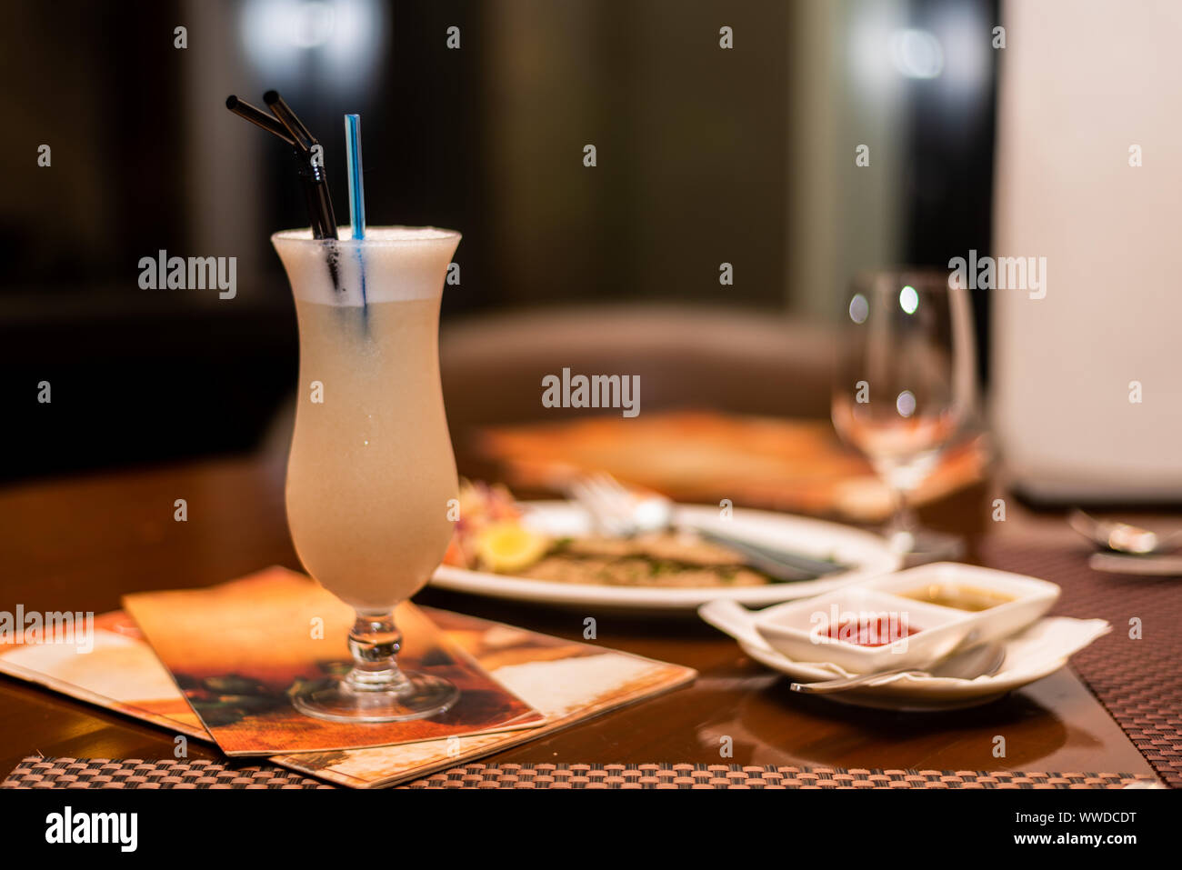 Interiors of restaurant with cocktail drink in focus and dish in ...