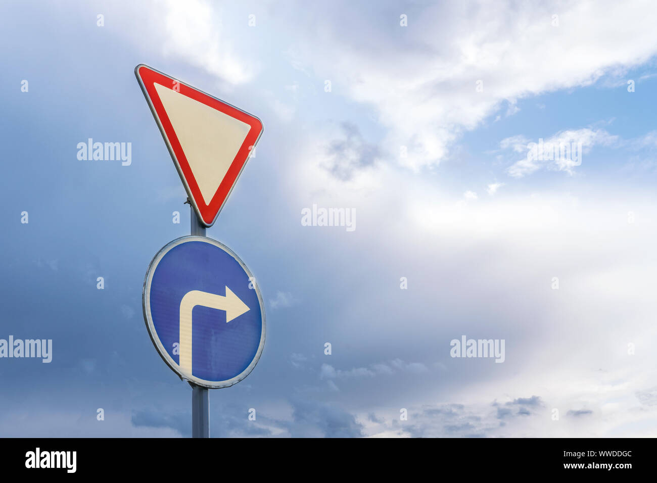Give way and turn right, against the backdrop of dramatic sky and ...