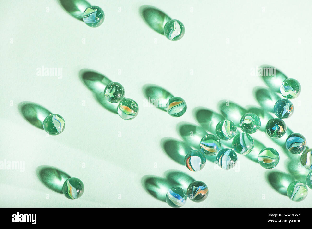 Little glass balls scattering on mint background Stock Photo - Alamy