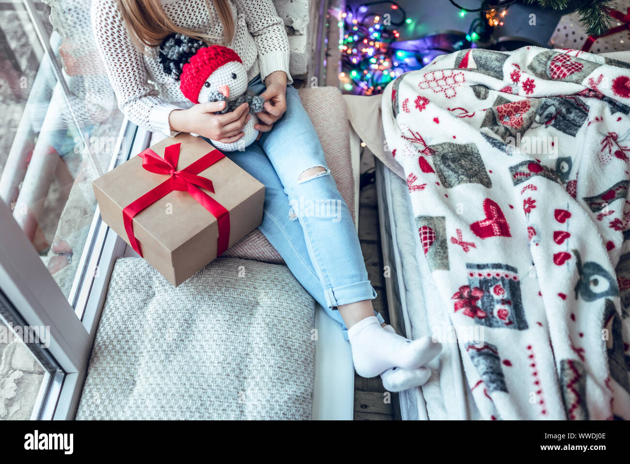 No face. Child little girl sitting by the window with a snowman. Top ...