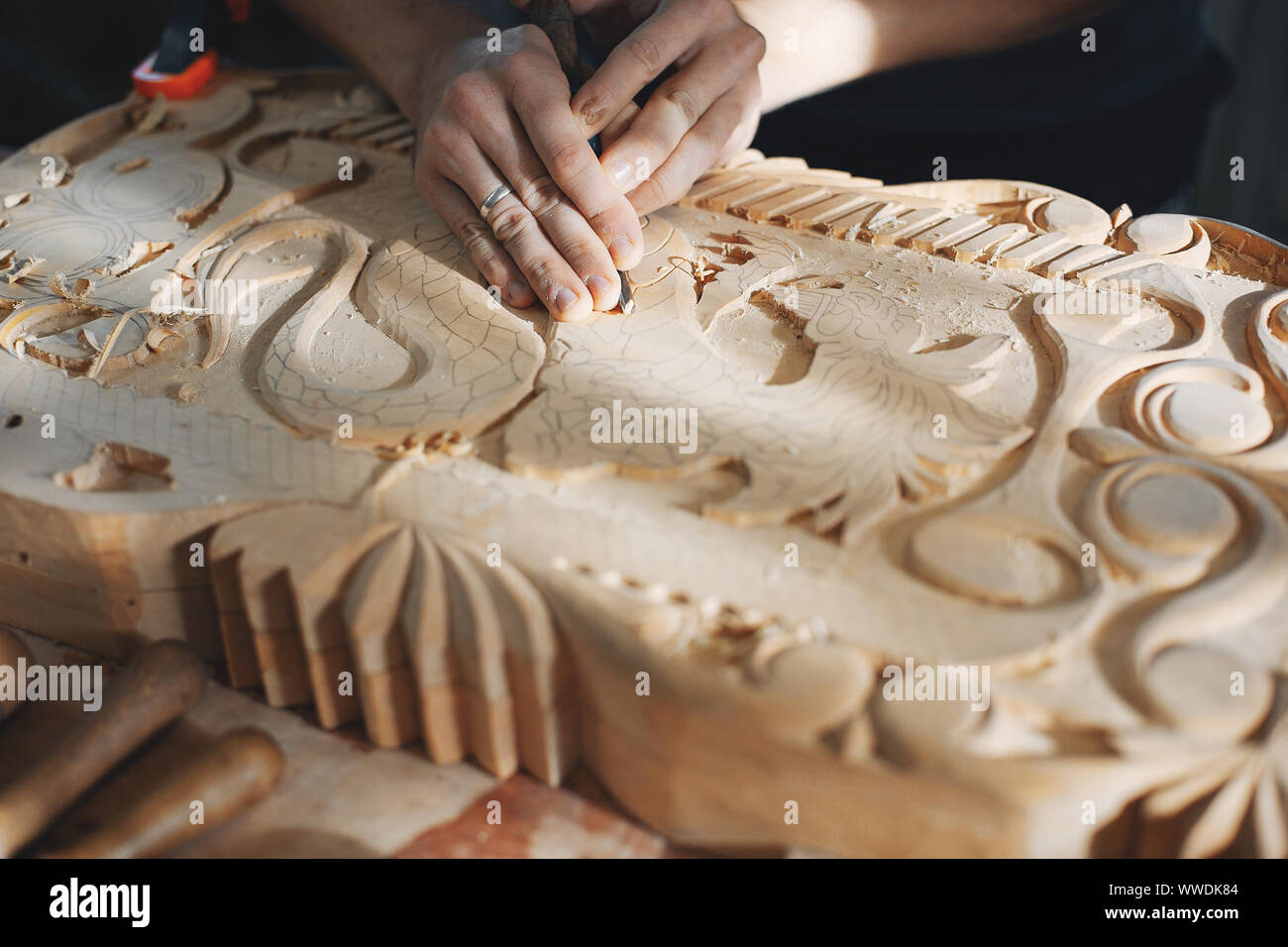 A man carves a tree. The carpenter works with jigsaw in a studio. An ...