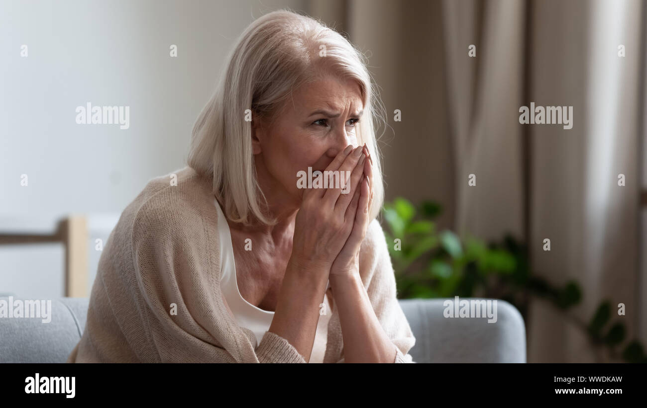 Upset mature woman crying, sitting alone, feeling lonely and unwell ...