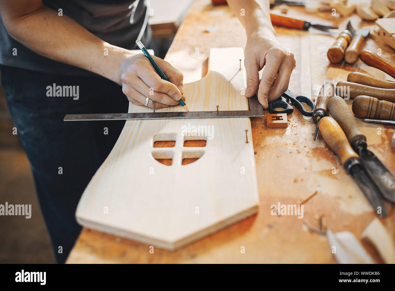 A man carves a tree. The carpenter works in a studio. An engineer ...