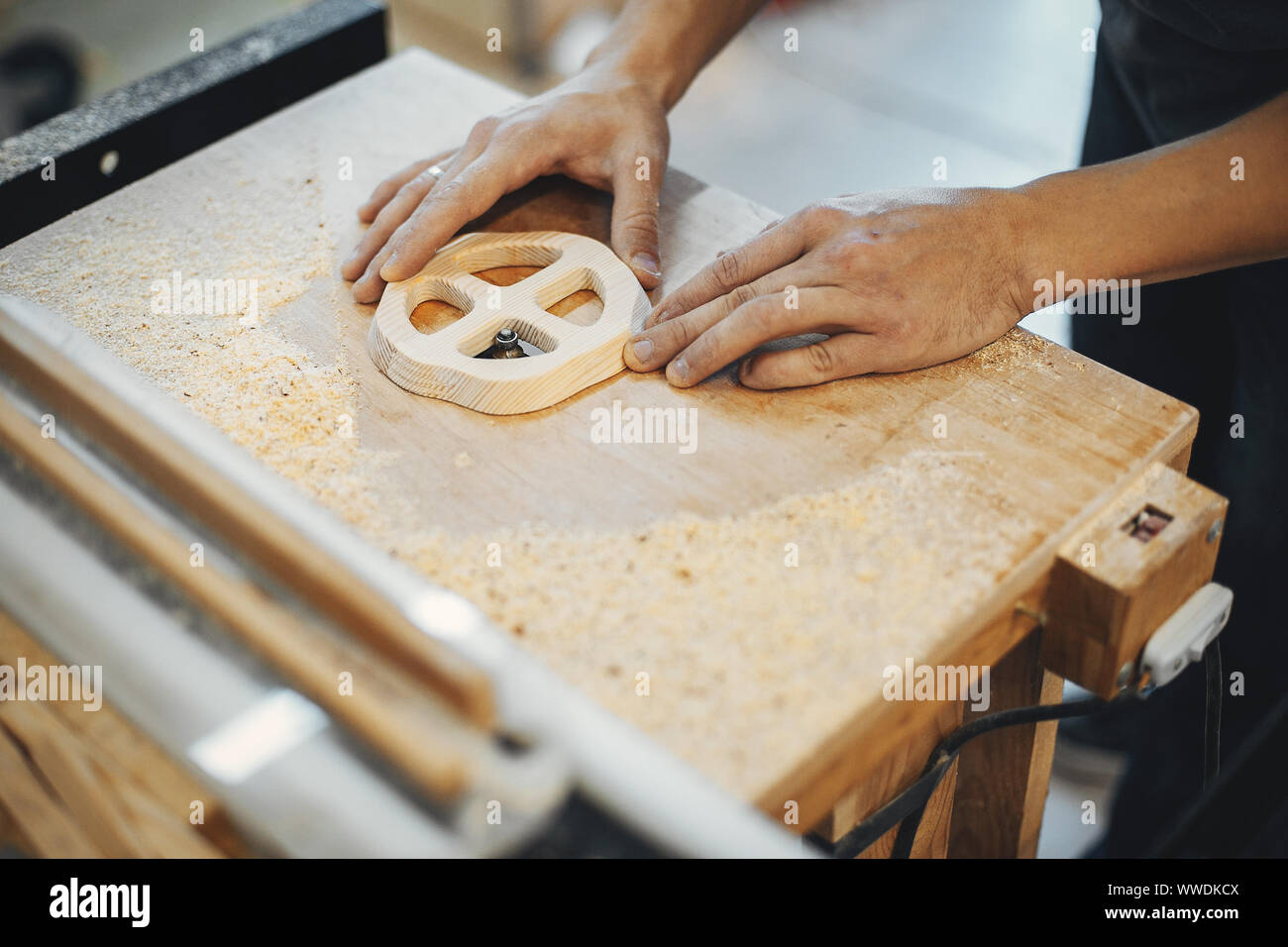 A man carves a tree. The carpenter works in a studio. An engineer ...