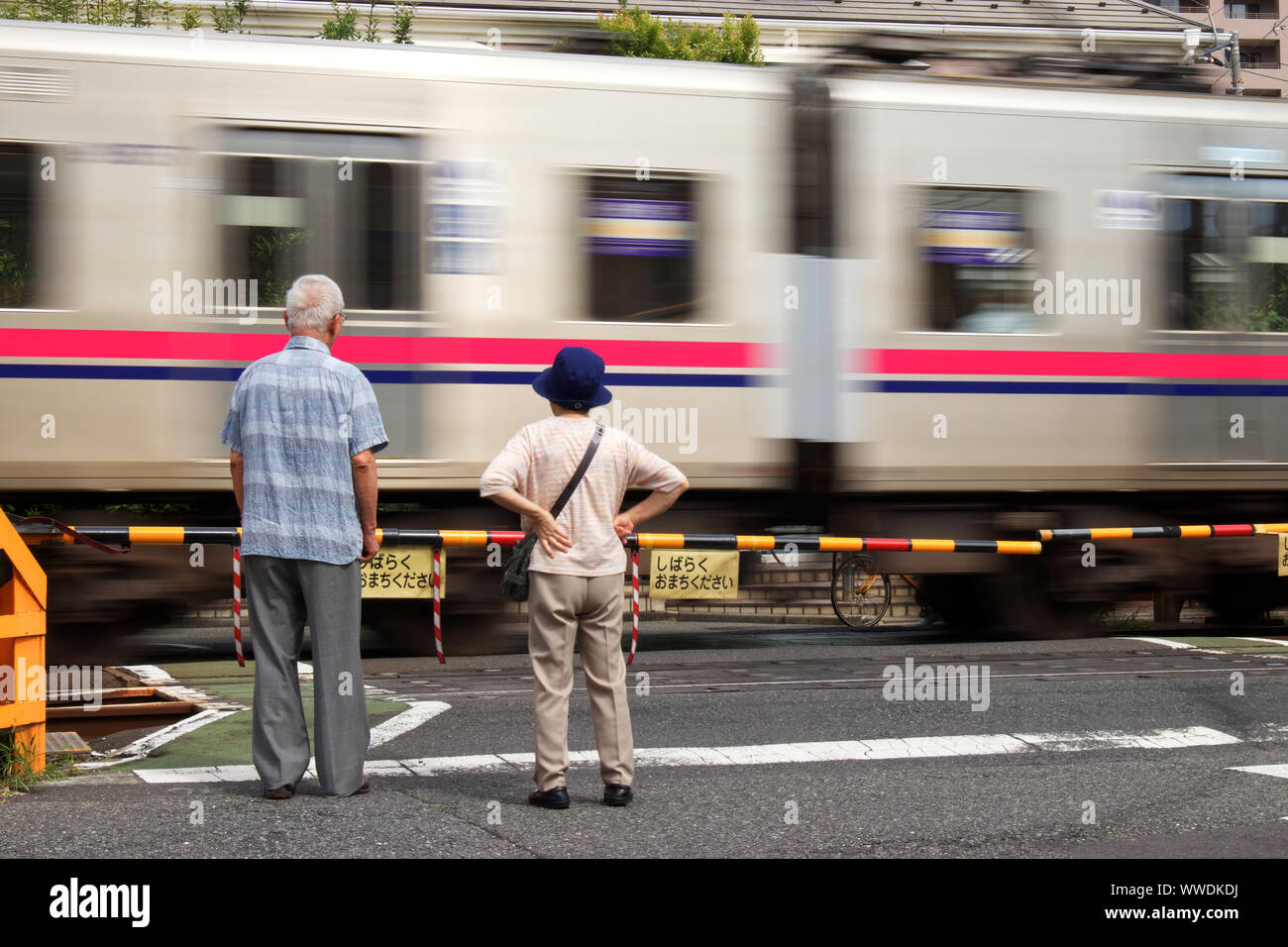 Concept image of Senior couple watching trains going by at intersection ...