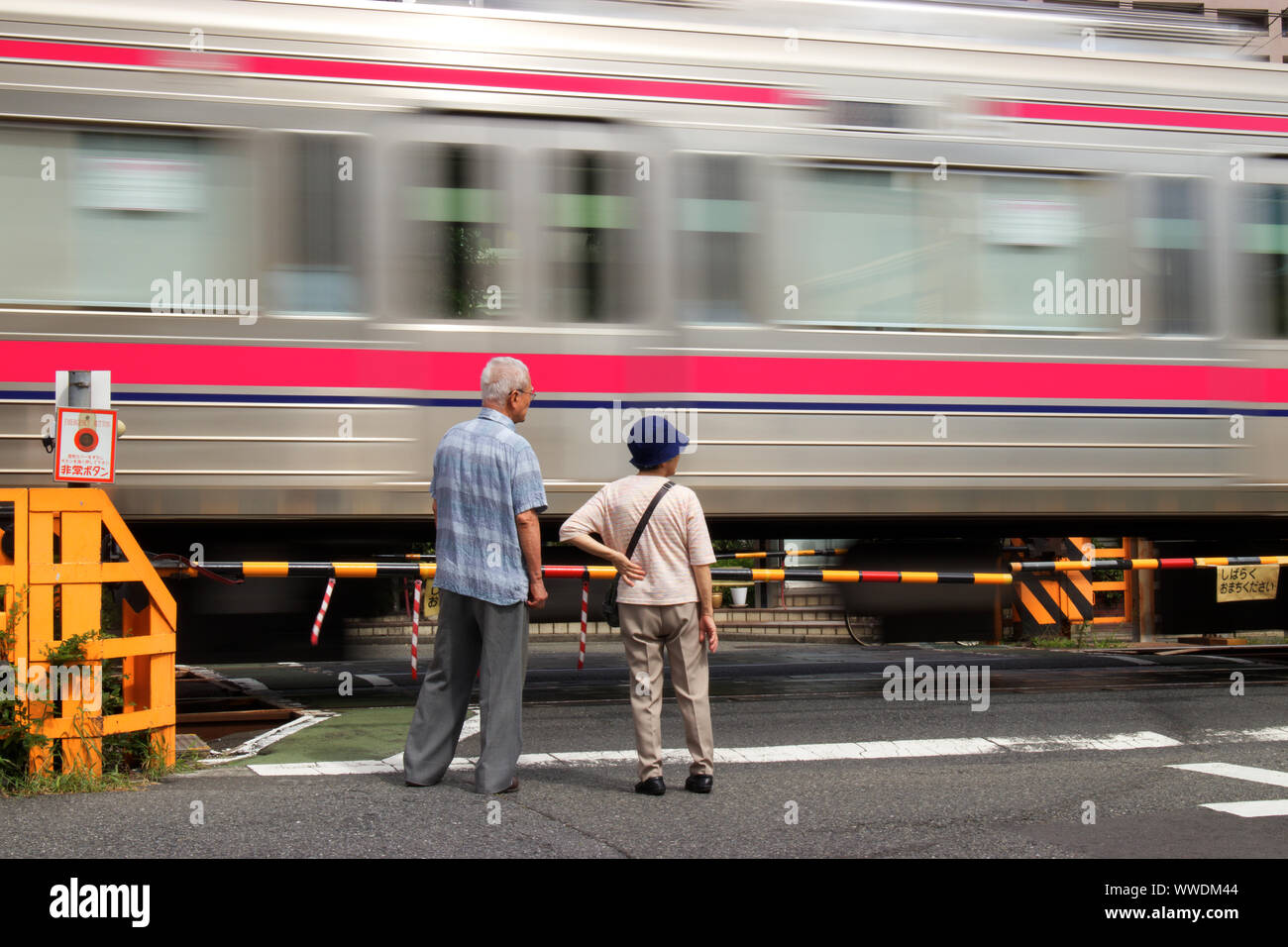 Concept image of Senior couple watching trains going by at intersection ...
