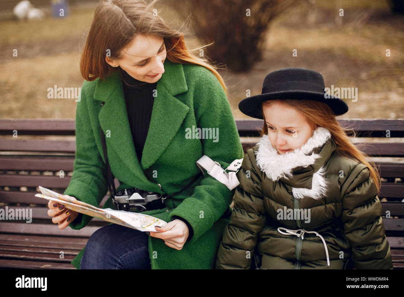 Fashionable mother with daughter. Family with a travel map Stock Photo ...