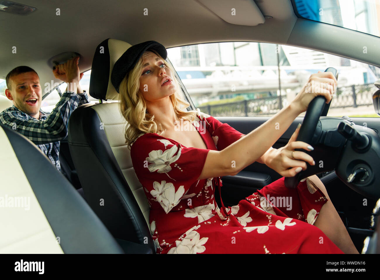 Photo of woman driver driving and male passenger riding in car during ...