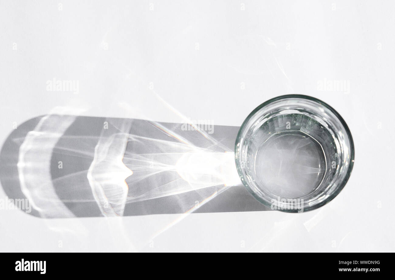 Water glass with strong shadows on white background Stock Photo - Alamy