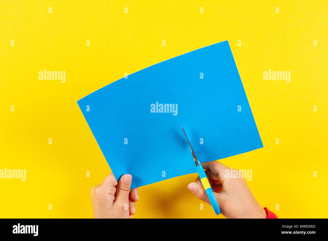 Kid's hands cutting colored paper with scissors Stock Photo - Alamy