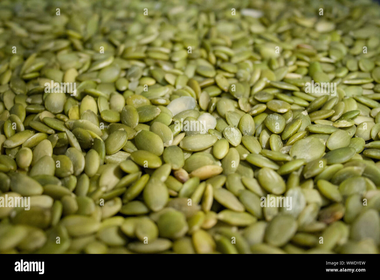 Macro background texture of green raw pumpkin seeds Stock Photo - Alamy