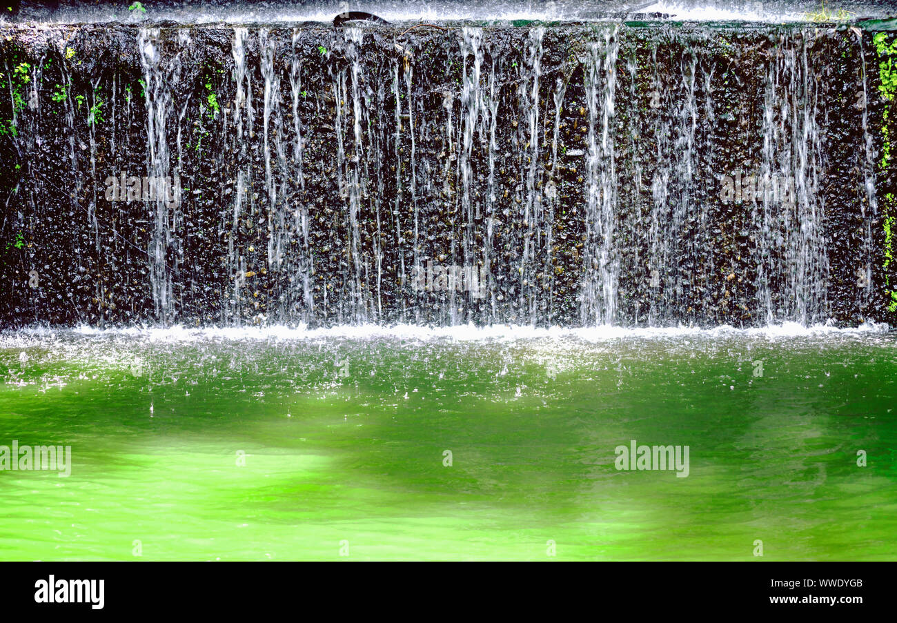 Waterfall built green water on rock wall inside mountain Gives a ...