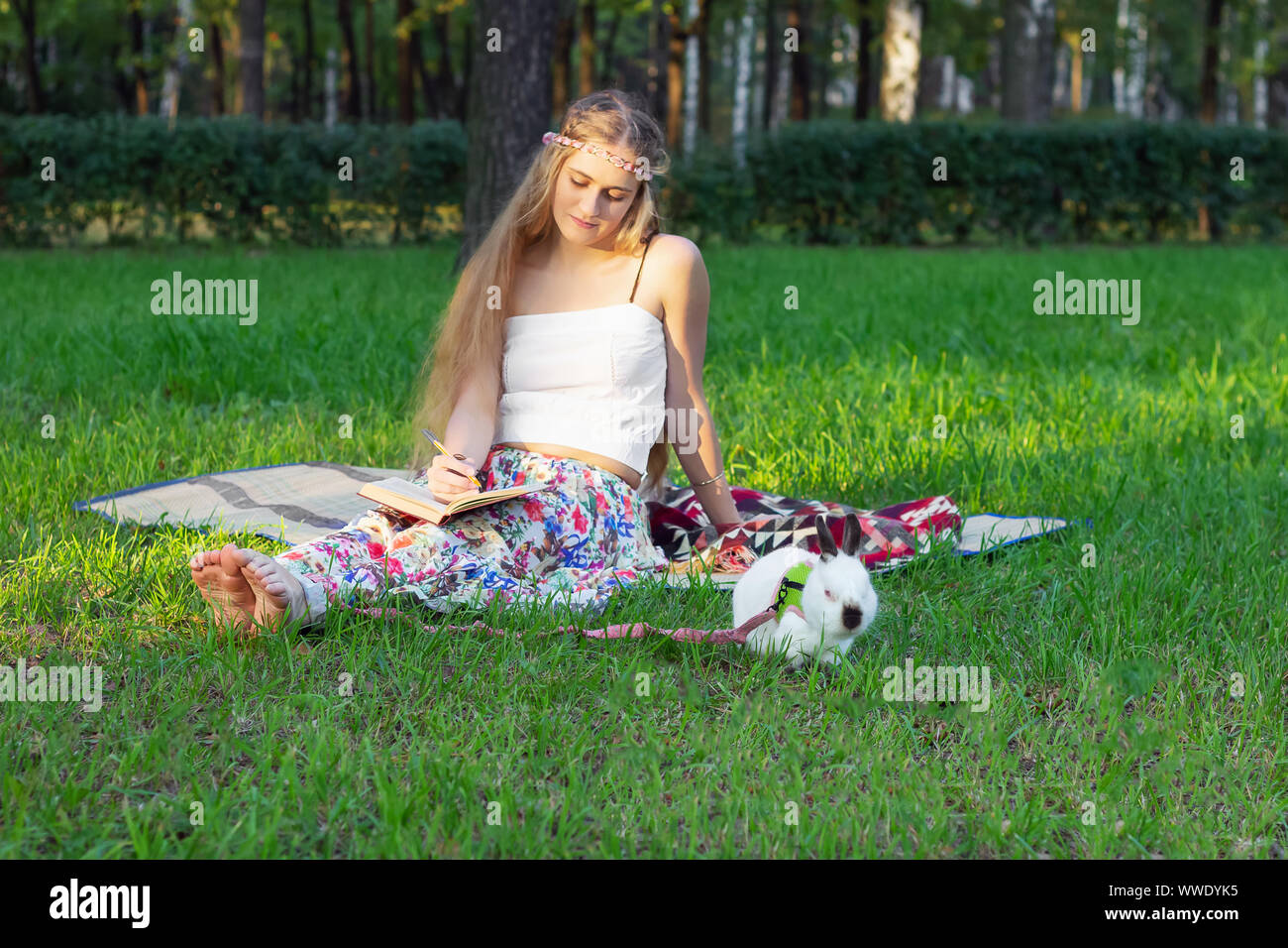poet girl in the park write poem rabbit homework Stock Photo - Alamy