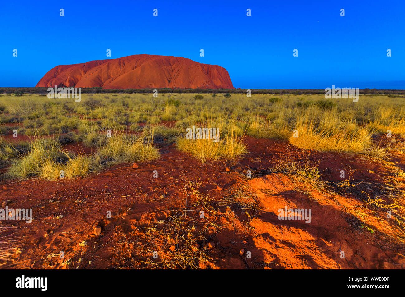 Red sand of Australian outback in dry season. Ayers Rock, huge ...