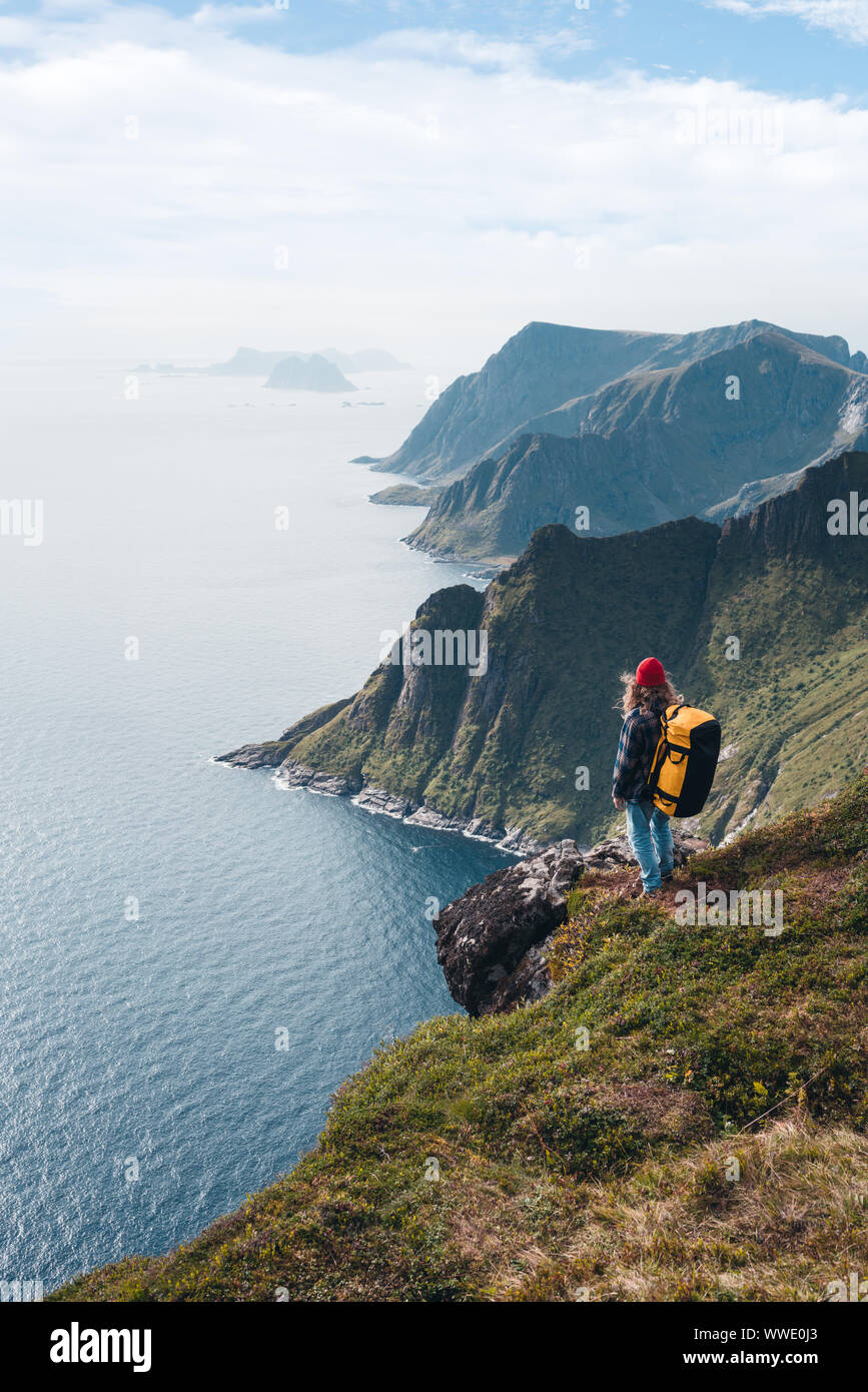 Man wearing professional backpack traveling alone on the high mountains. Traveler standing on ...