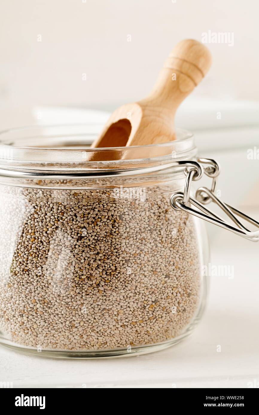 Whole, organic white chia seeds heap in glass storage jar on white ...