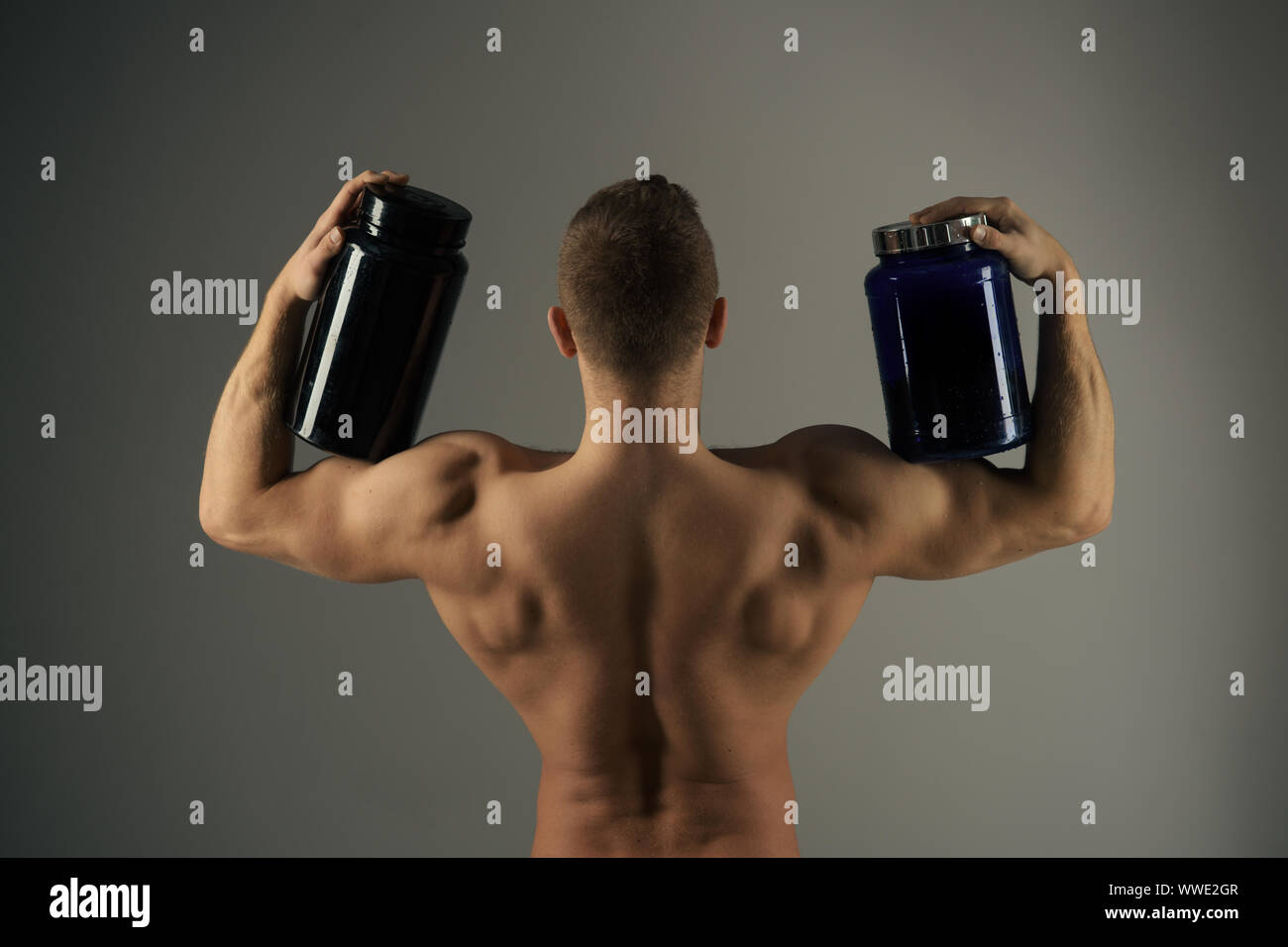 Putting the best into your body. Muscular man with vitamin supplements ...