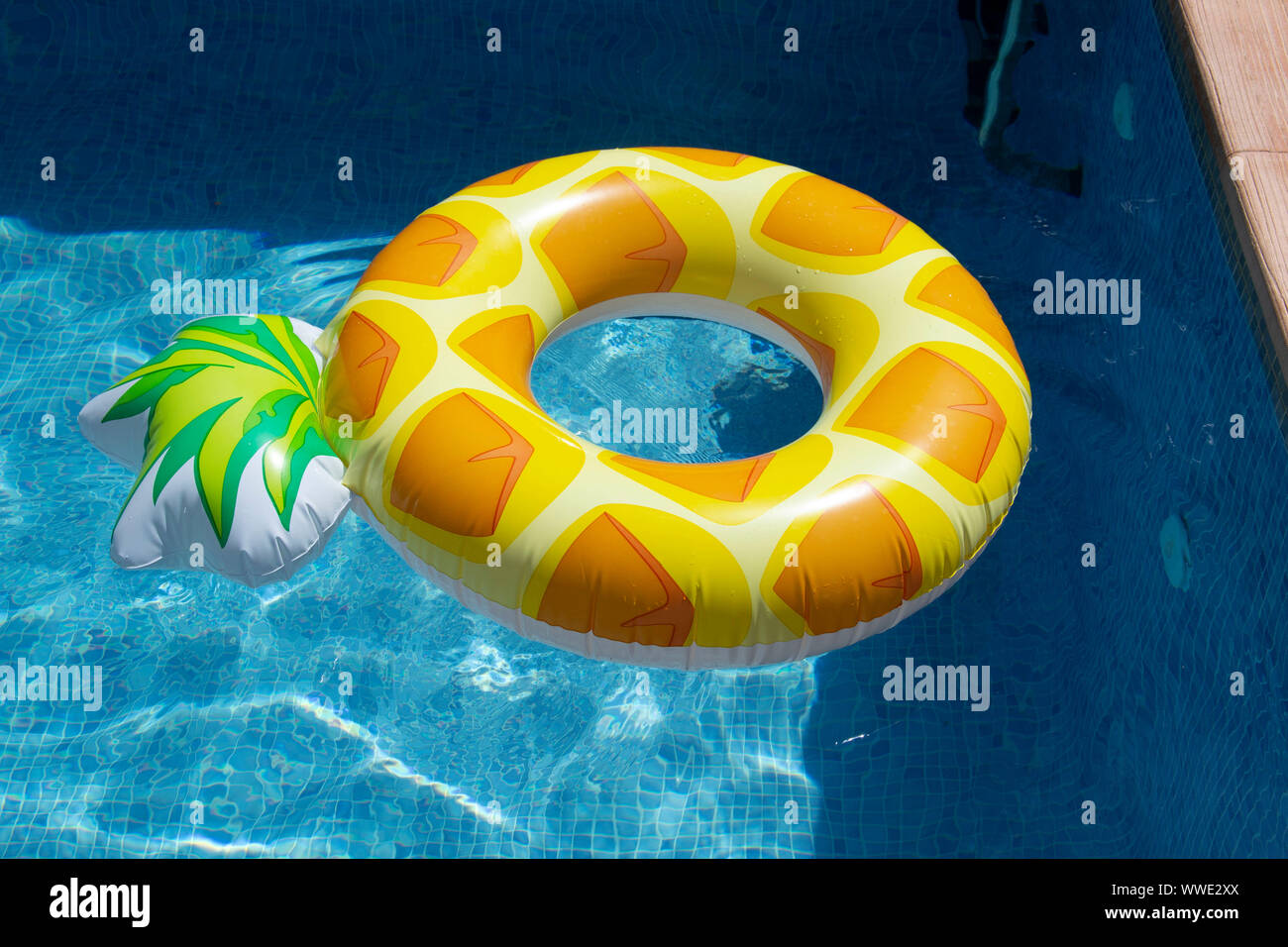 inflatable pineapple ring floating in swimming pool Stock Photo - Alamy