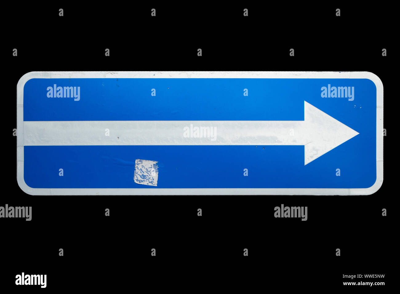 One way street in direction of arrow road sign isolated on black Stock ...