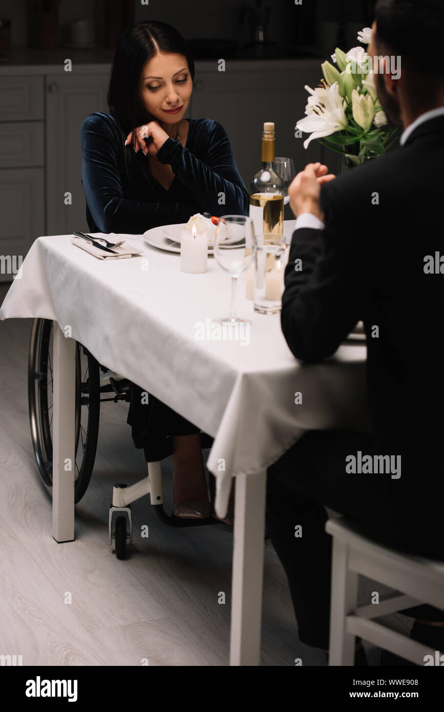 back view of man having romantic dinner with beautiful disabled ...