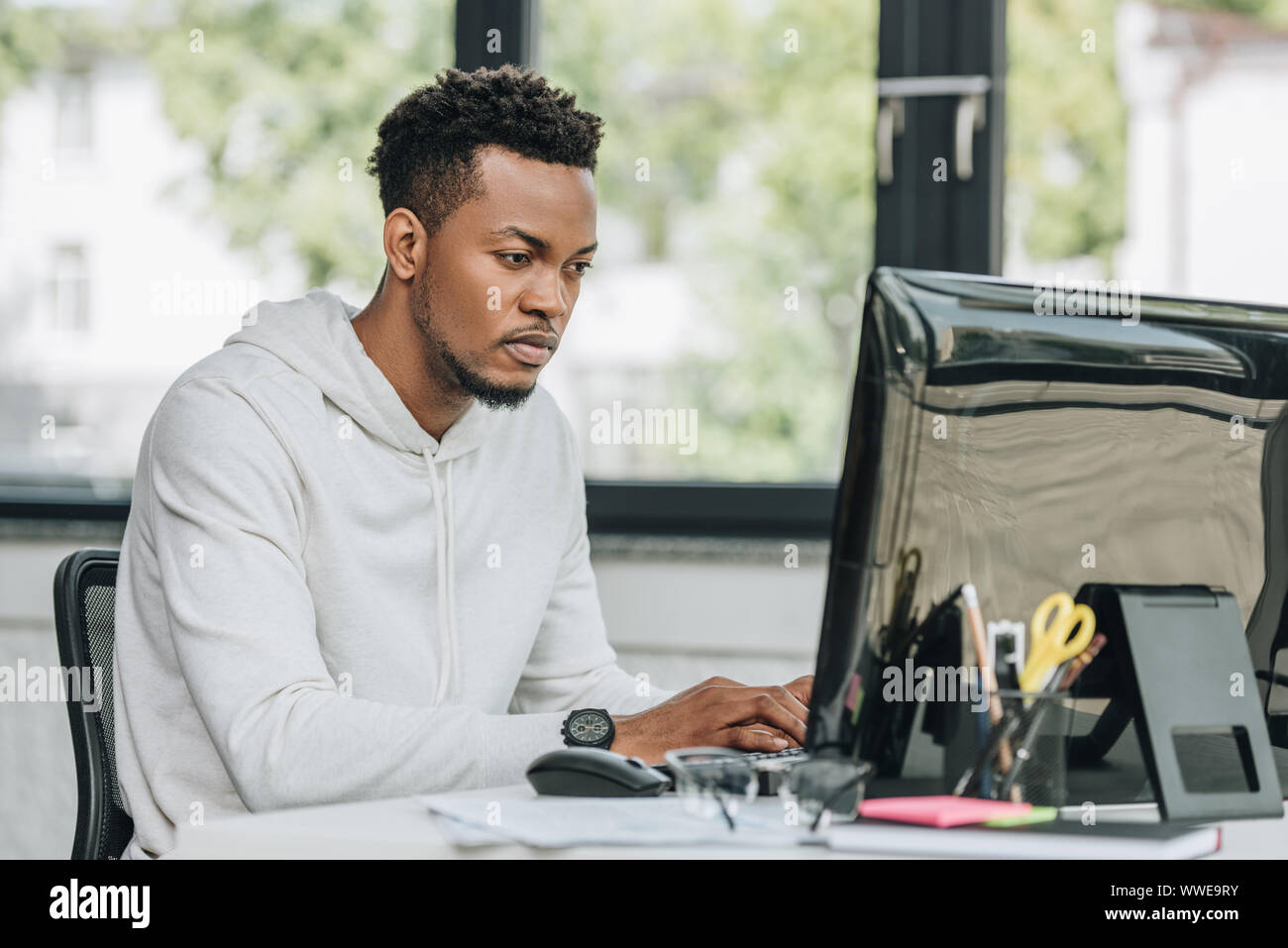 concentrated african american programmer working on computer in office Stock Photo - Alamy