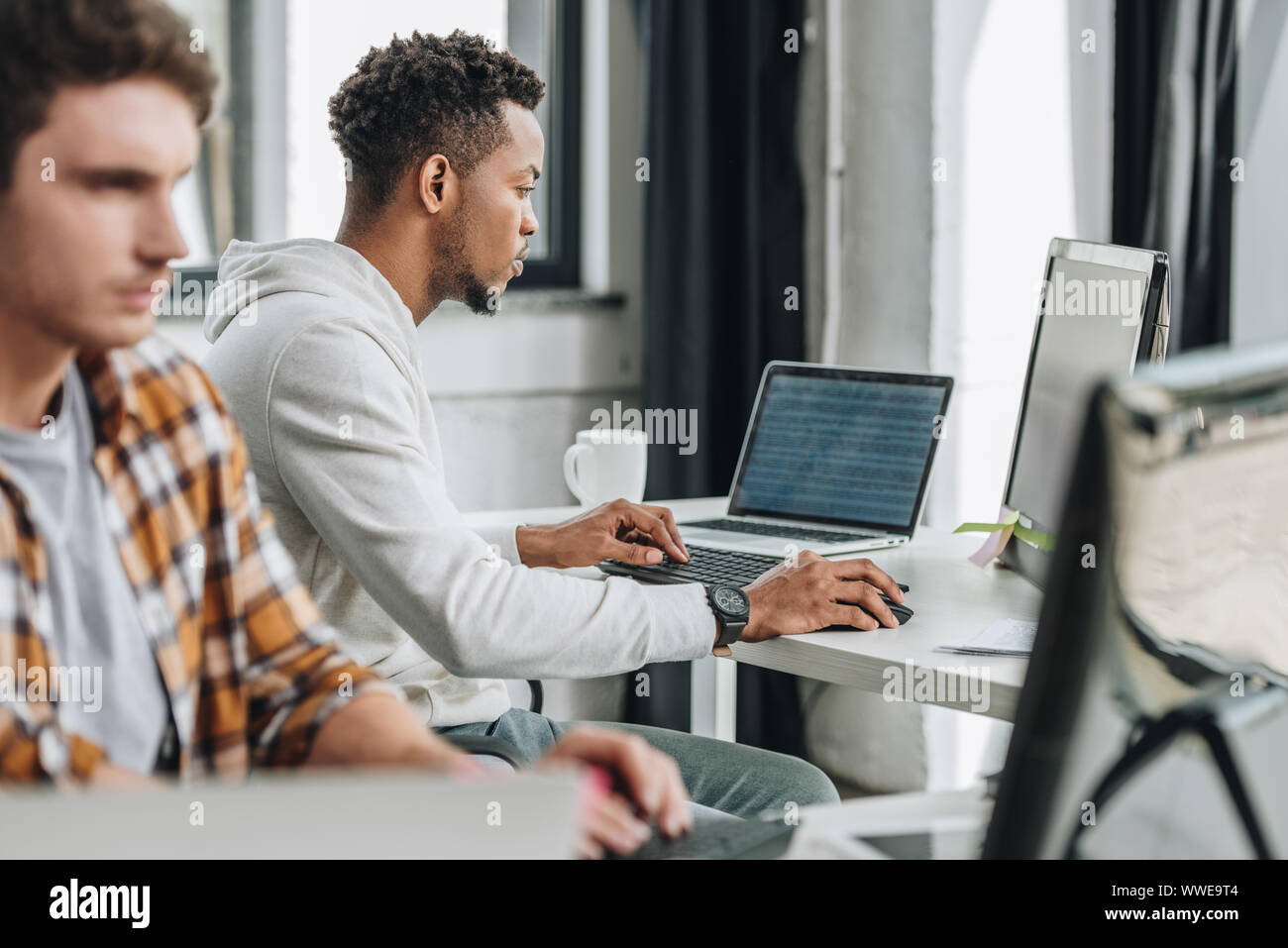 selective focus of two multicultural programmers working together in ...