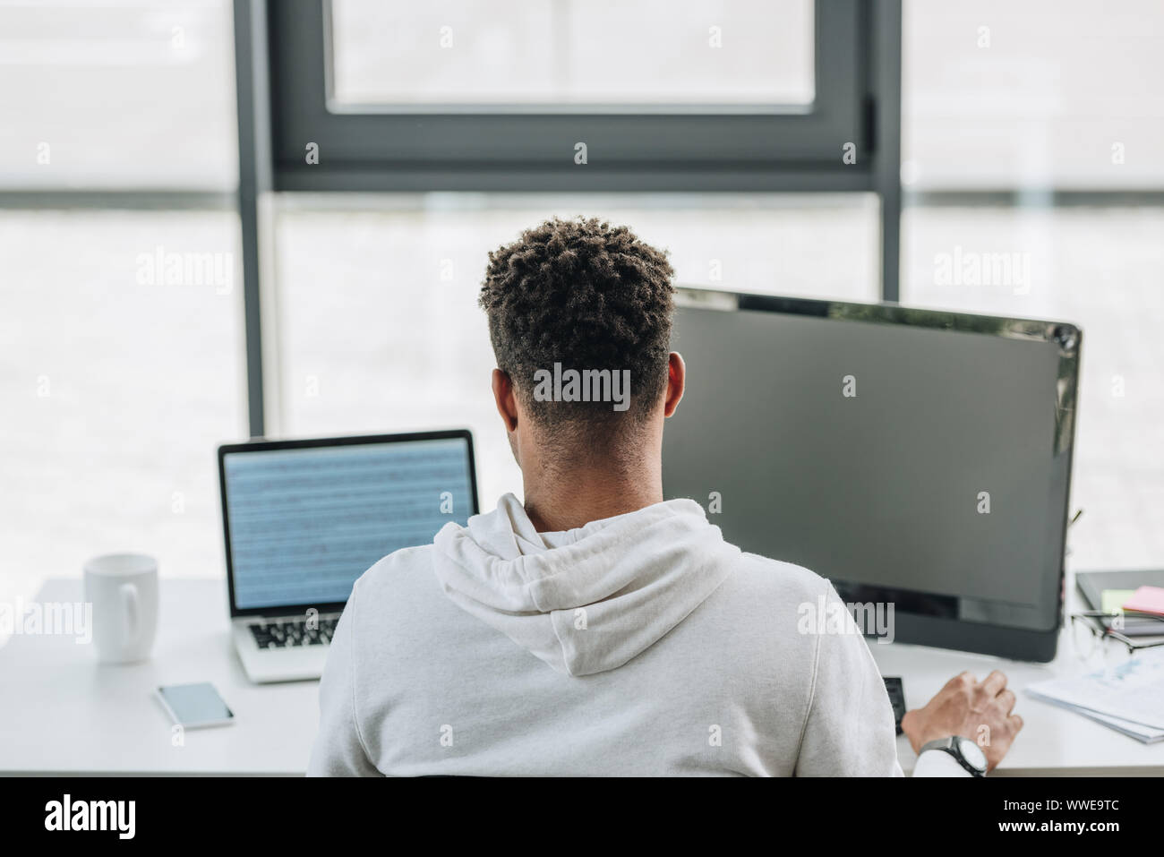 back view of african american programmer working on computers in office ...