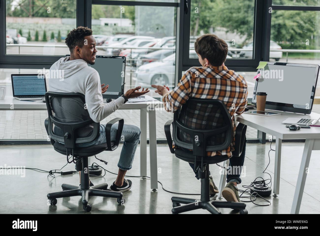two young multicultural programmers discussing ideas while working ... two young multicultural programmers discussing ideas while working ...