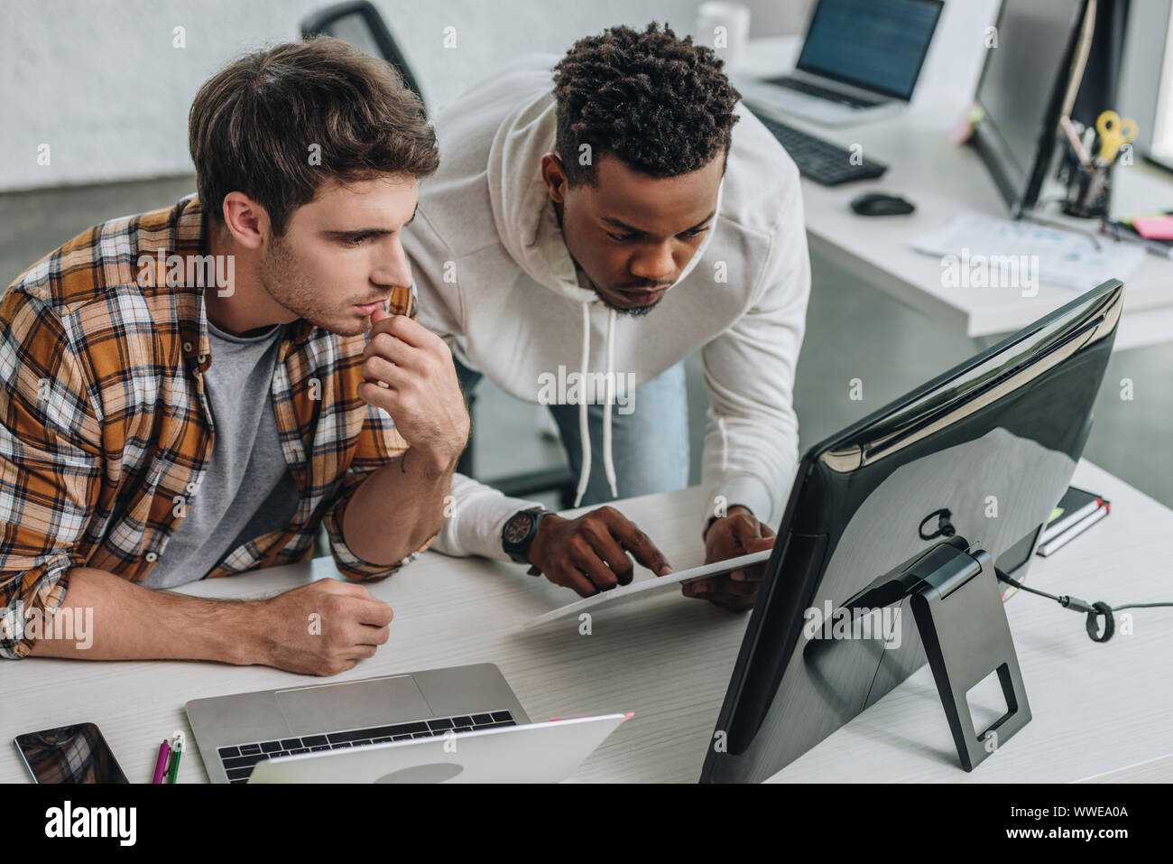 two serious multicultural programmers working in office together Stock ...