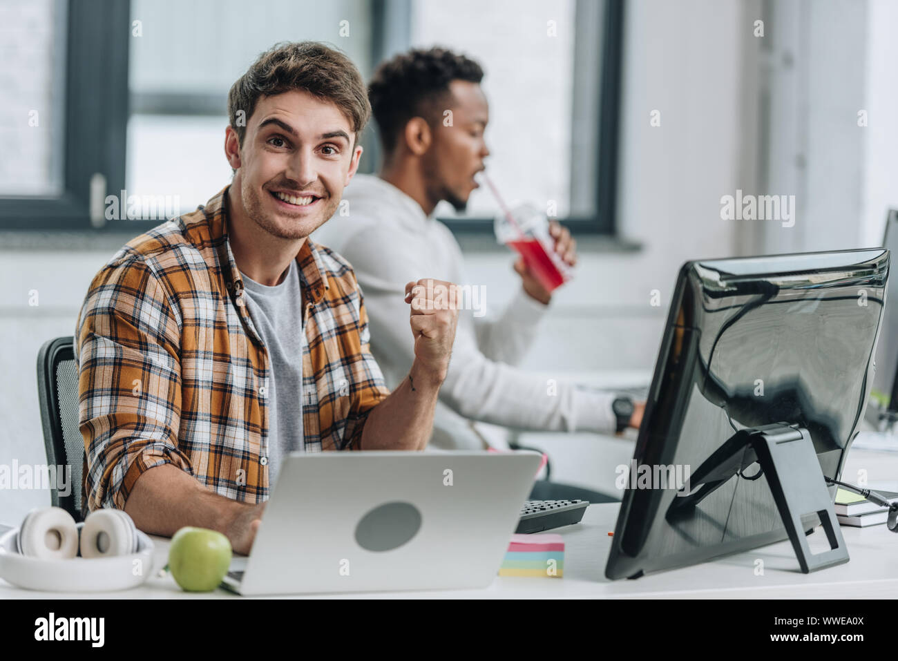 happy programmer looking at camera and showing winner gesture while ...